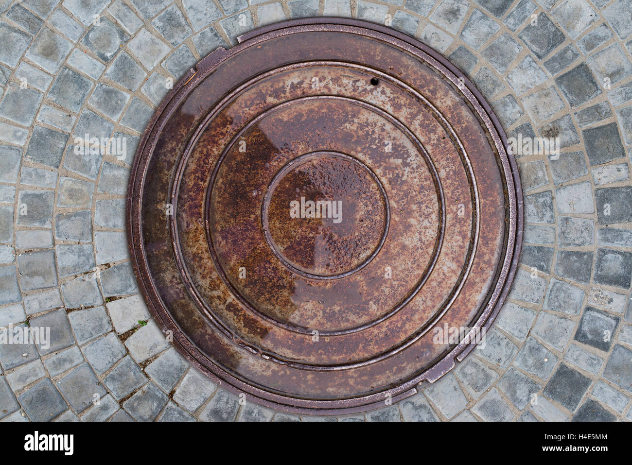 Closeup photo of Old Sewer rust manhole cover on the urban asphalt road ...