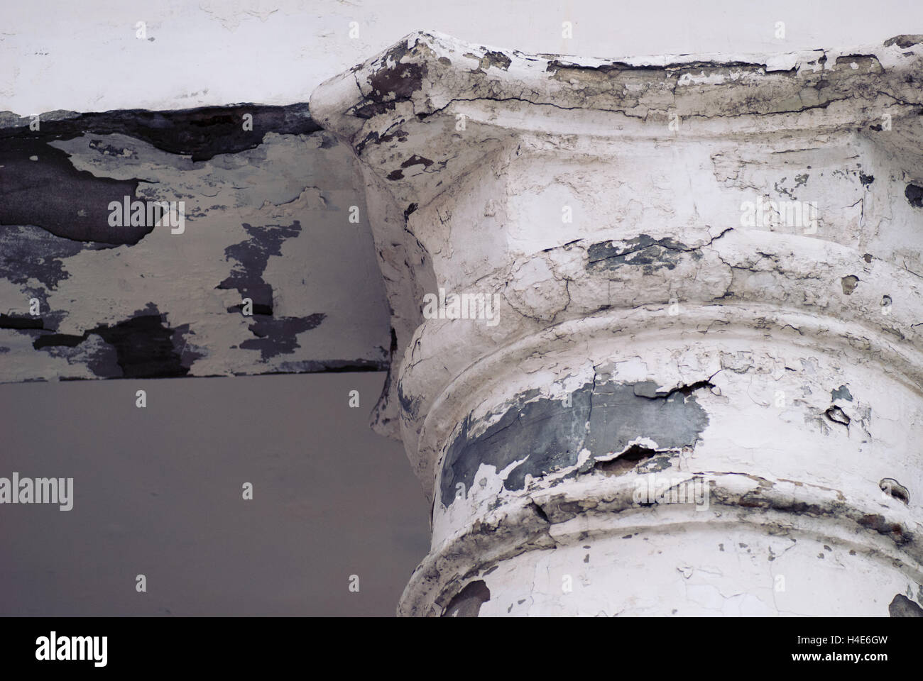 Old abandoned cracked column capital with peel of the paint. Fragment ...