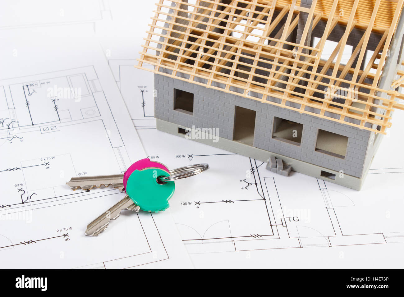 Home keys and small house under construction lying on electrical ...