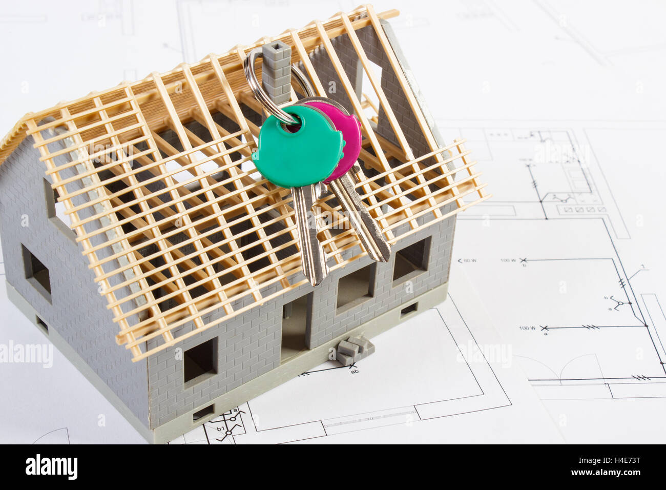 Home keys and small house under construction lying on electrical ...