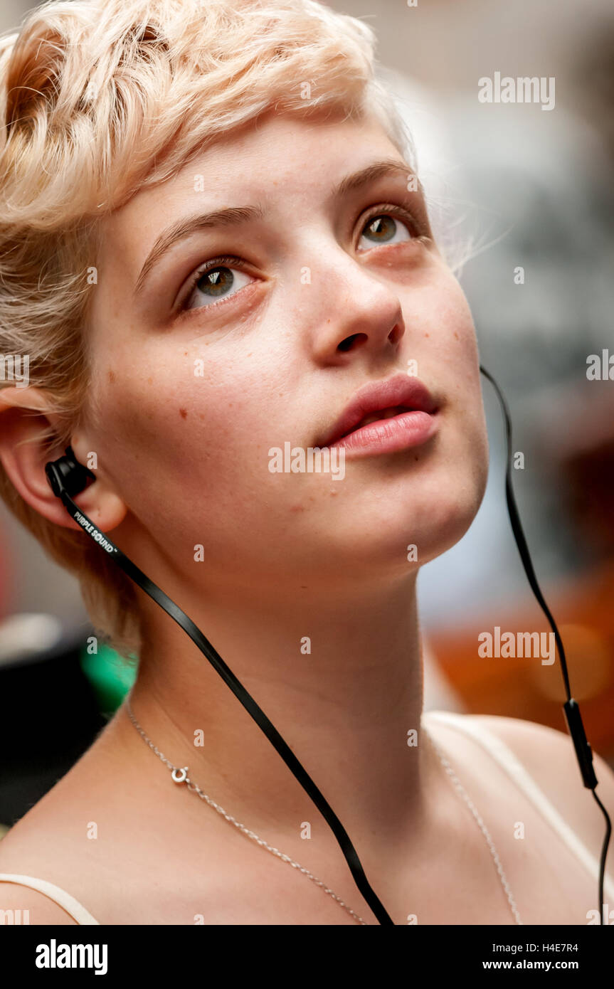 Model wearing in-ear buds, or headphones, to listen to their music ...
