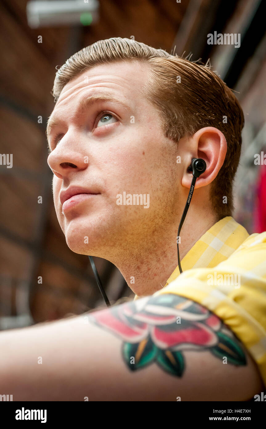 Model wearing in-ear buds, or headphones, to listen to their music ...