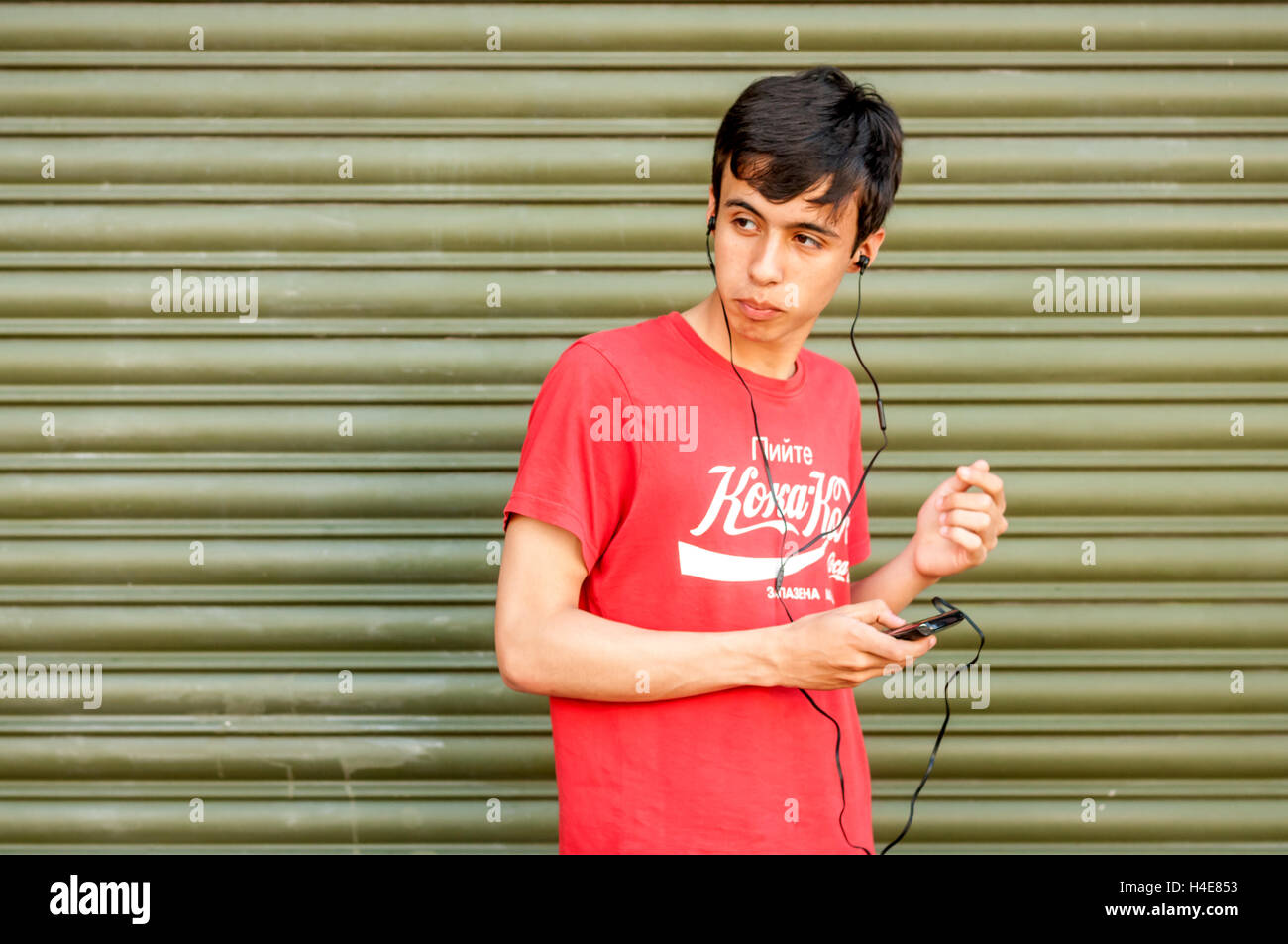 Model wearing in-ear buds, or headphones, to listen to their music ...