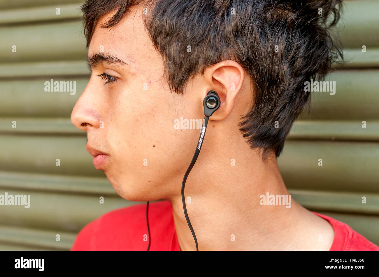 Model wearing in-ear buds, or headphones, to listen to their music ...