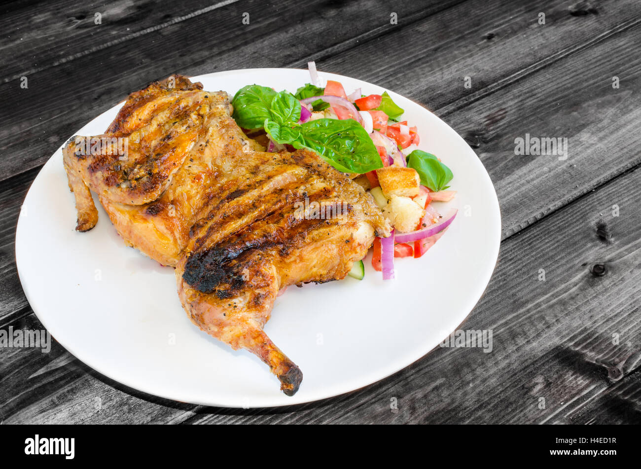 Chicken under a brick with panzanella salad. Pollo al mattone Stock ...