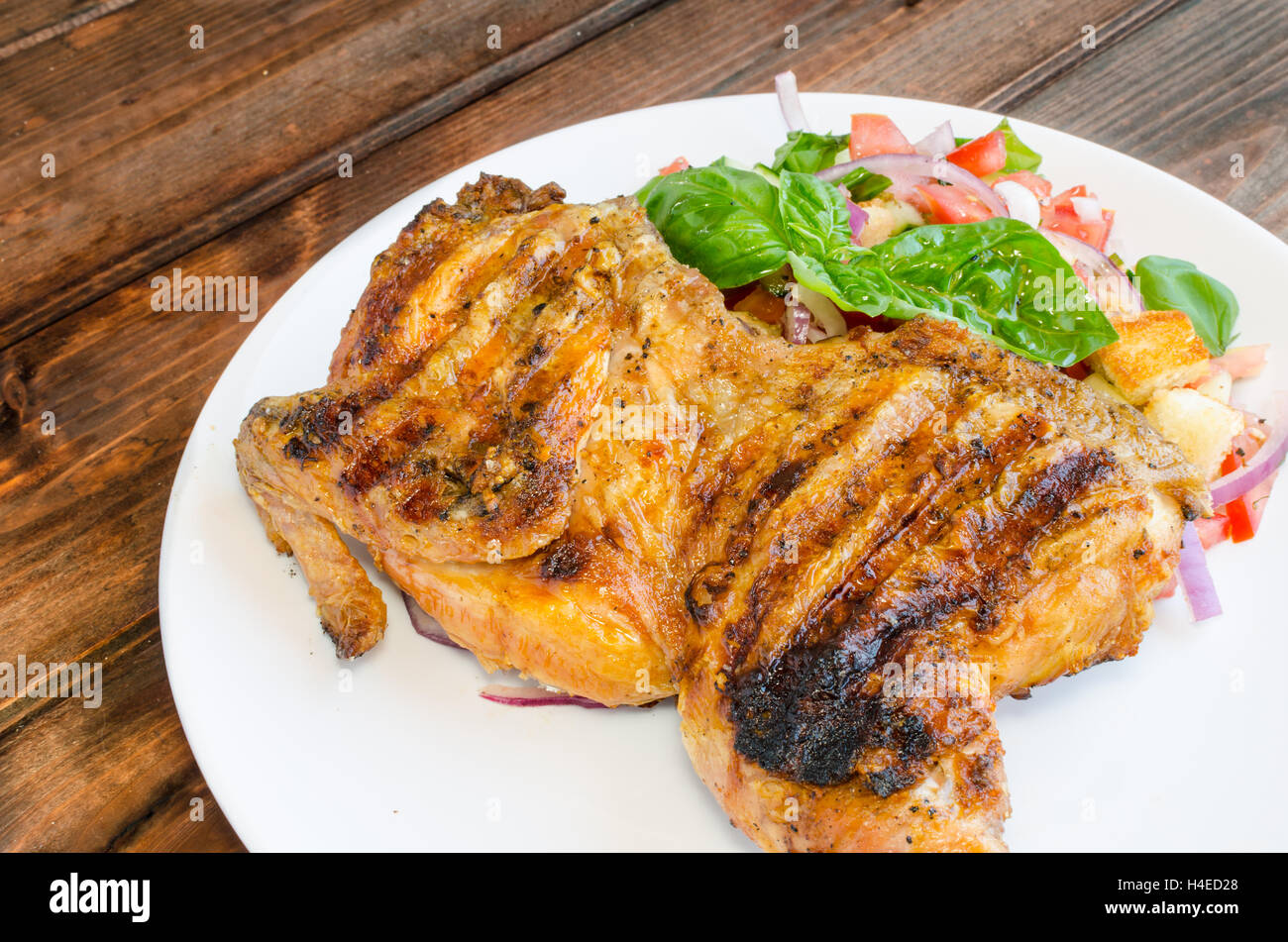 Chicken under a brick with panzanella salad. Pollo al mattone Stock ...