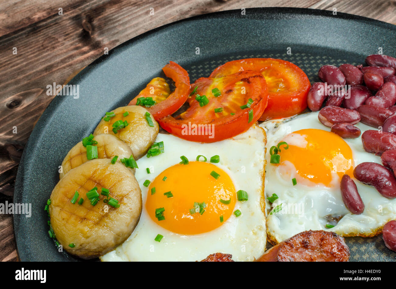 English breakfast on frying pan and wood table Stock Photo - Alamy