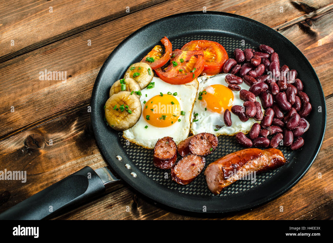 English breakfast on frying pan and wood table Stock Photo - Alamy