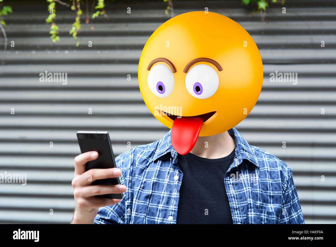 Emoji head man using a smartphone. Emoji concept Stock Photo - Alamy