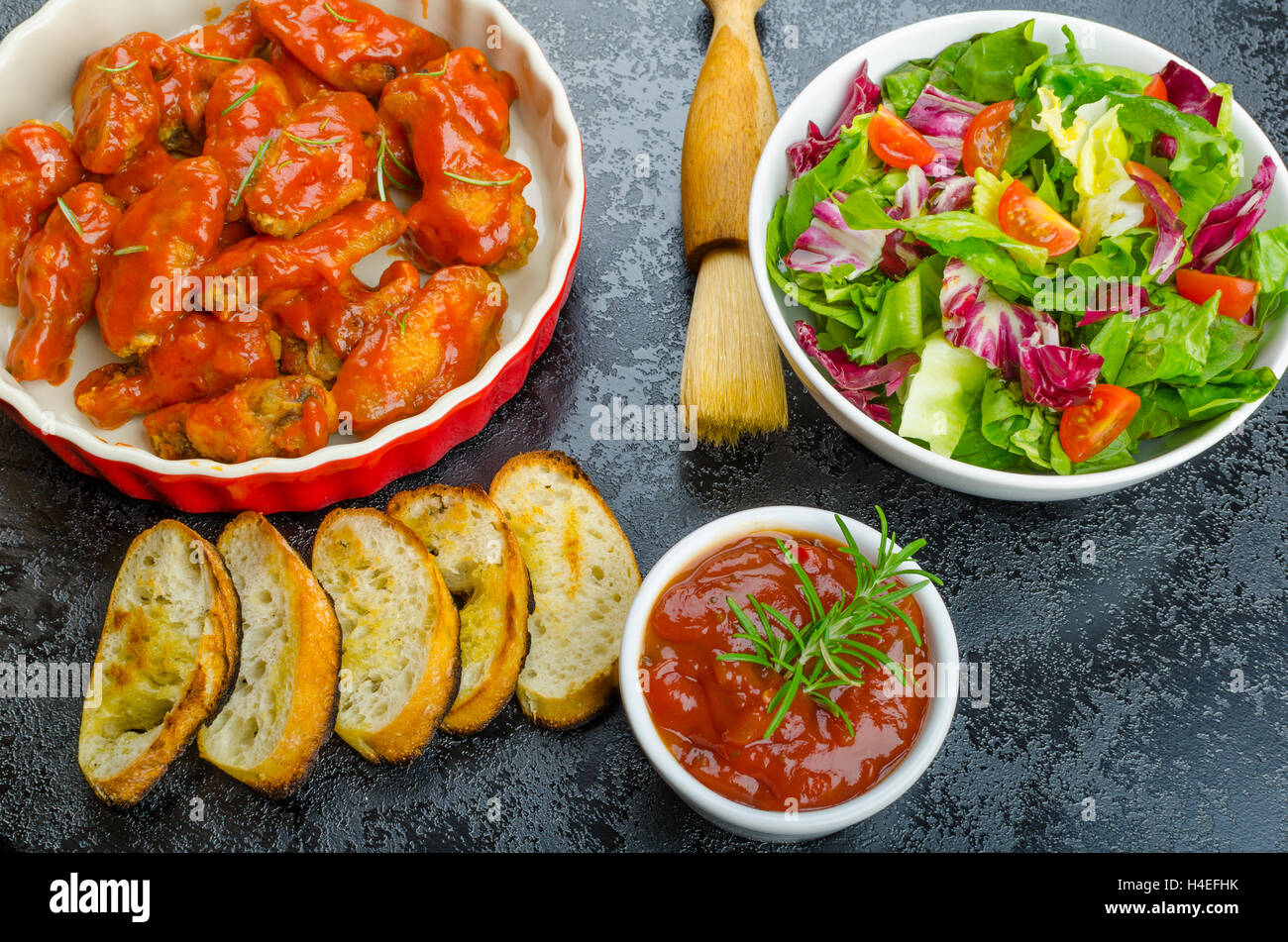 Hot chicken wings with spicy habanero sauce and mixed salad with cherry ...