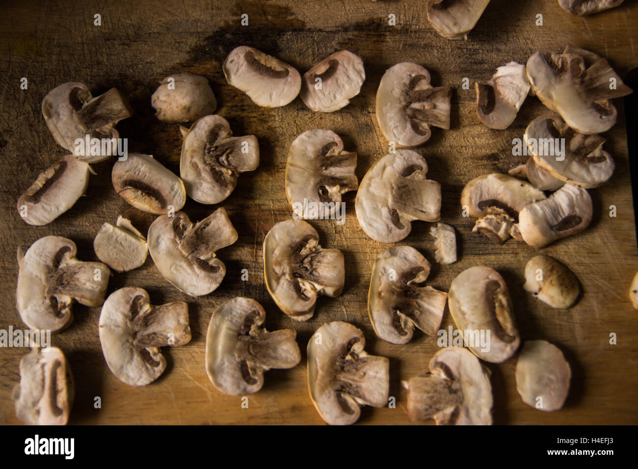 Cut button mushroom on the table in the kitchen ready to be cooked ...