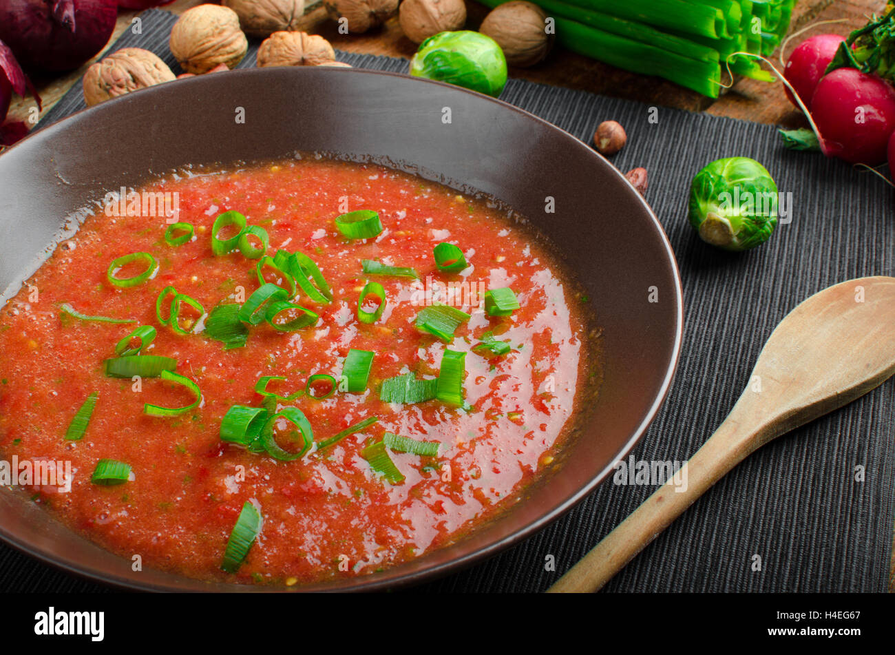 Hot salsa tomato with spring onion and red pepper on wood plate with ...