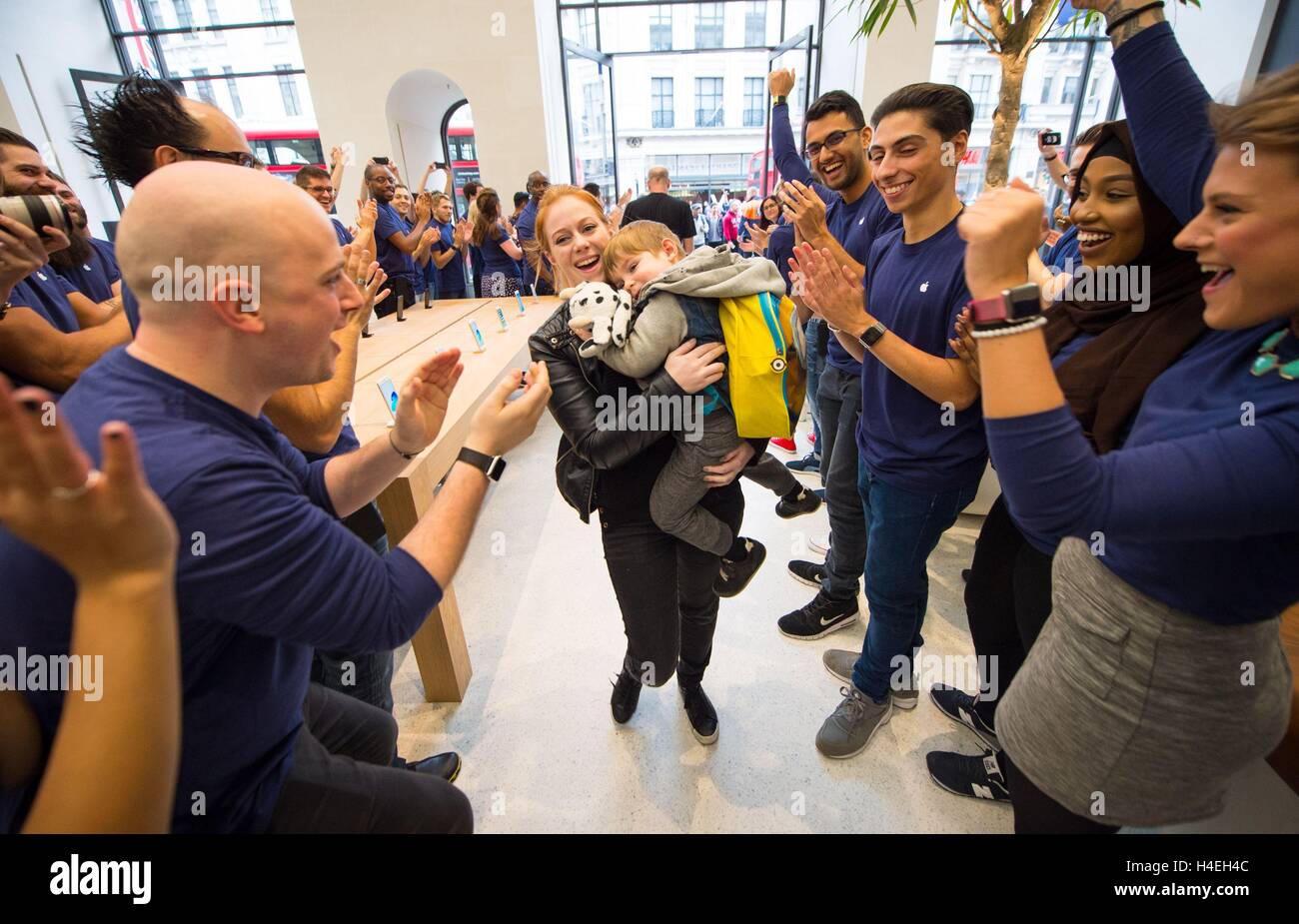 Apple employees welcome customers during the reopening of the Apple ...