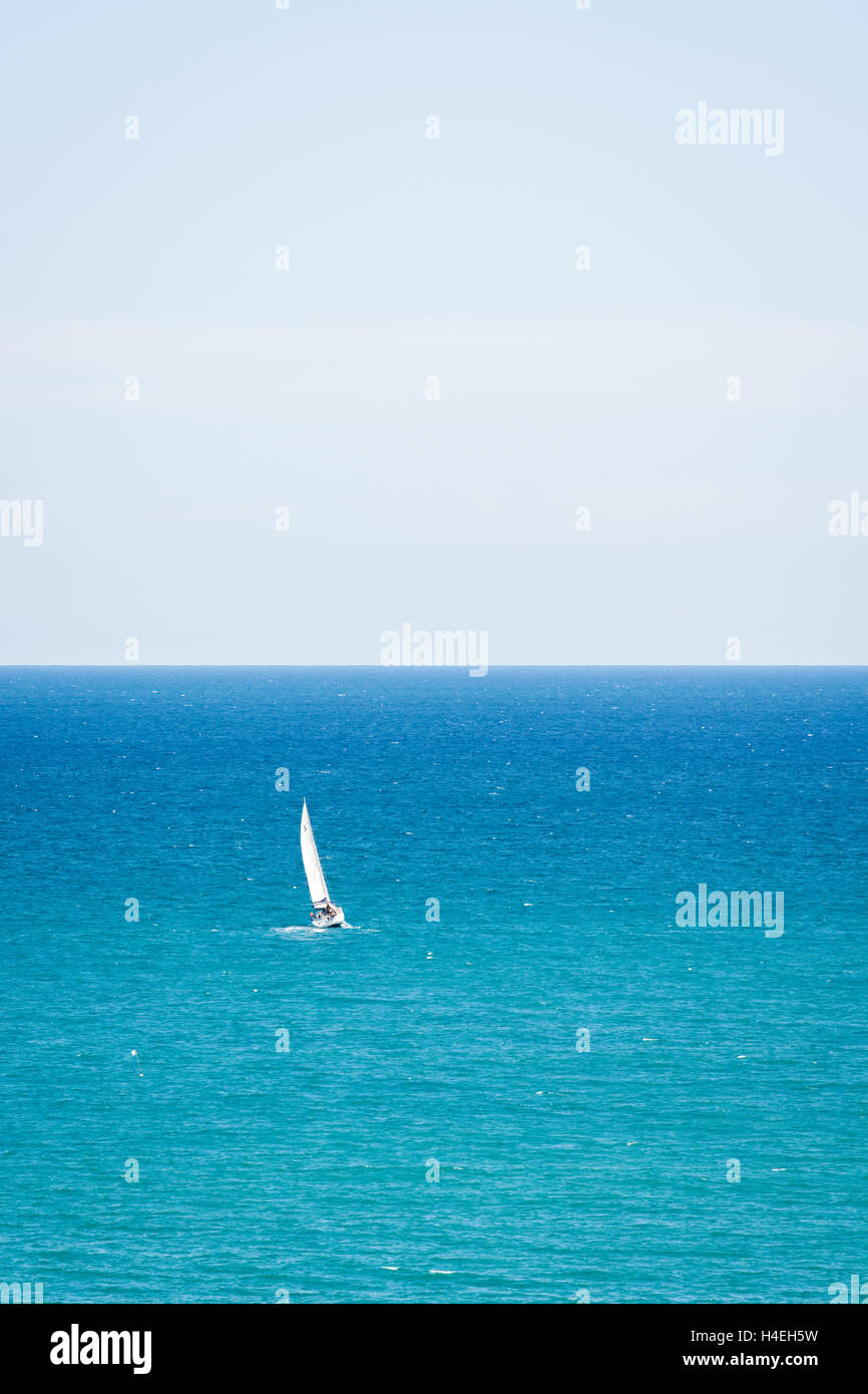 A yacht alone sailing by sea on a clear day Stock Photo - Alamy