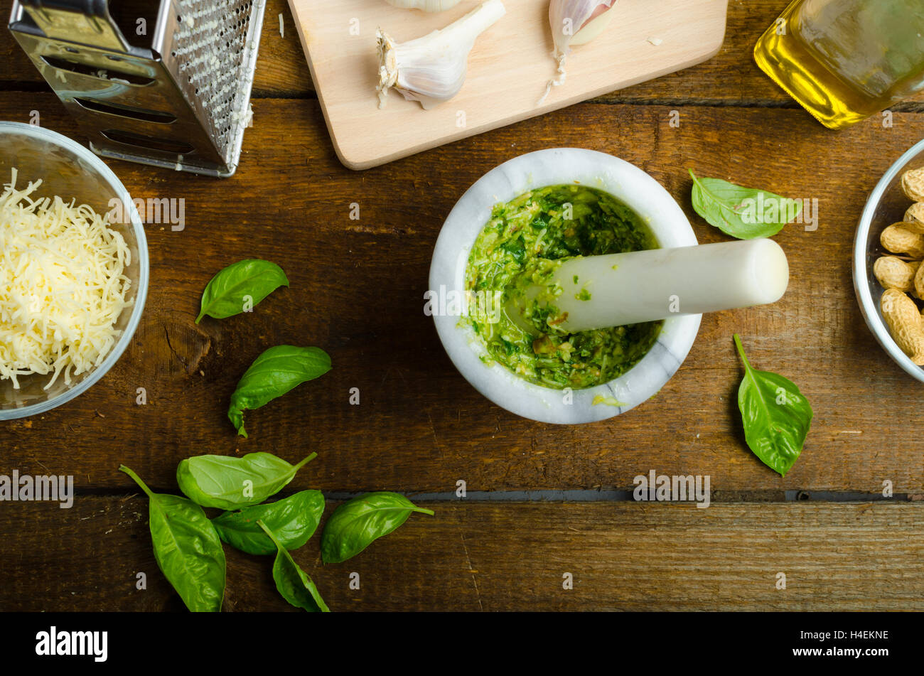 Making pesto - basil cheese, nuts, and olive oil in mortar Stock Photo ...