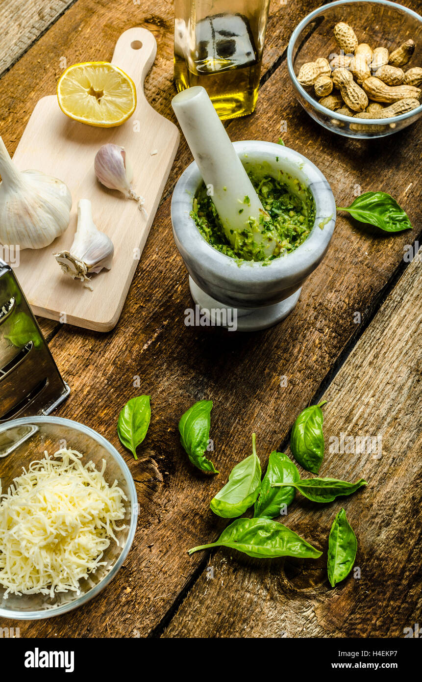 Making pesto - basil cheese, nuts, and olive oil in mortar Stock Photo ...
