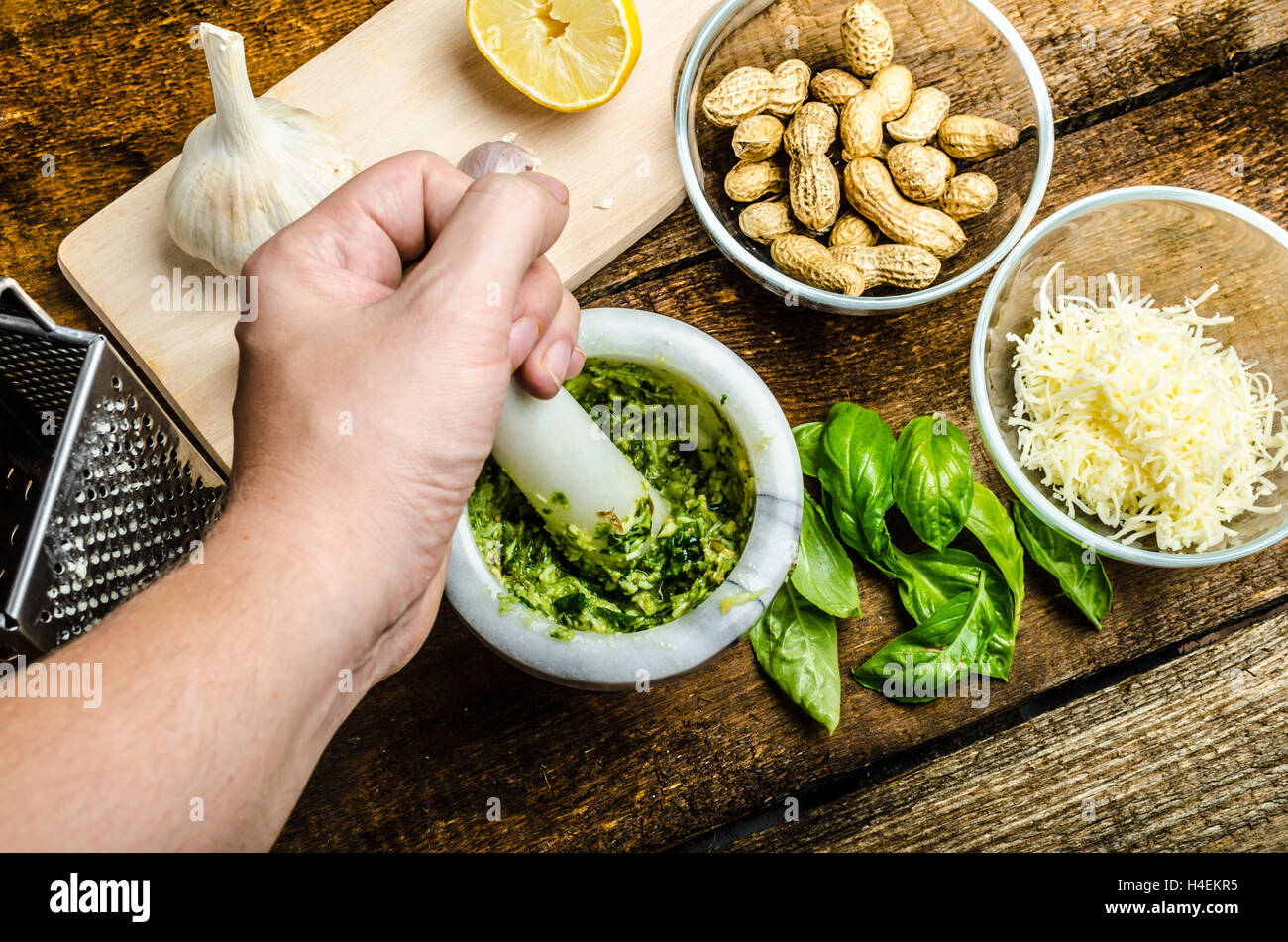 Making pesto - basil cheese, nuts, and olive oil in mortar Stock Photo ...