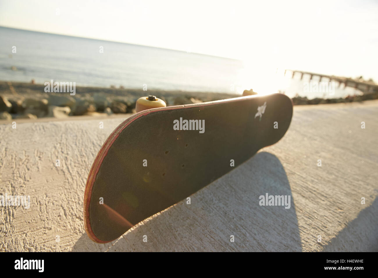 A skateboard lying on sunset on a shore at the sea Stock Photo - Alamy