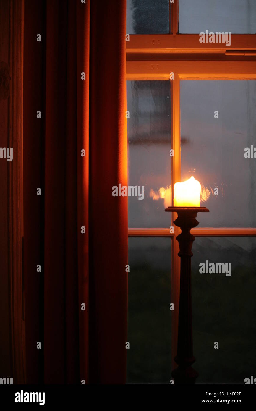 Candle in front of a window with curtain Stock Photo - Alamy