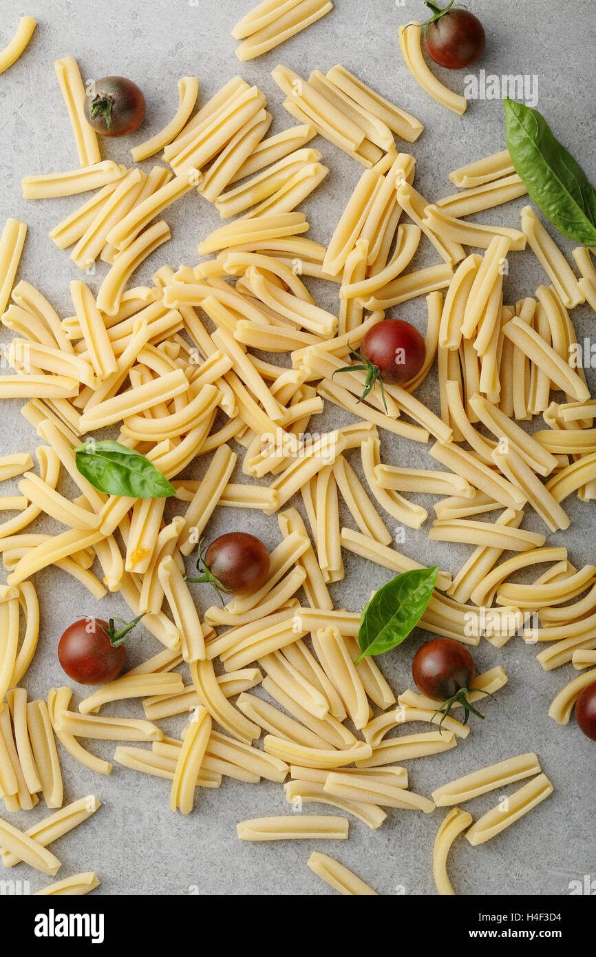 Raw pasta with tomato on concrete, food top view Stock Photo - Alamy