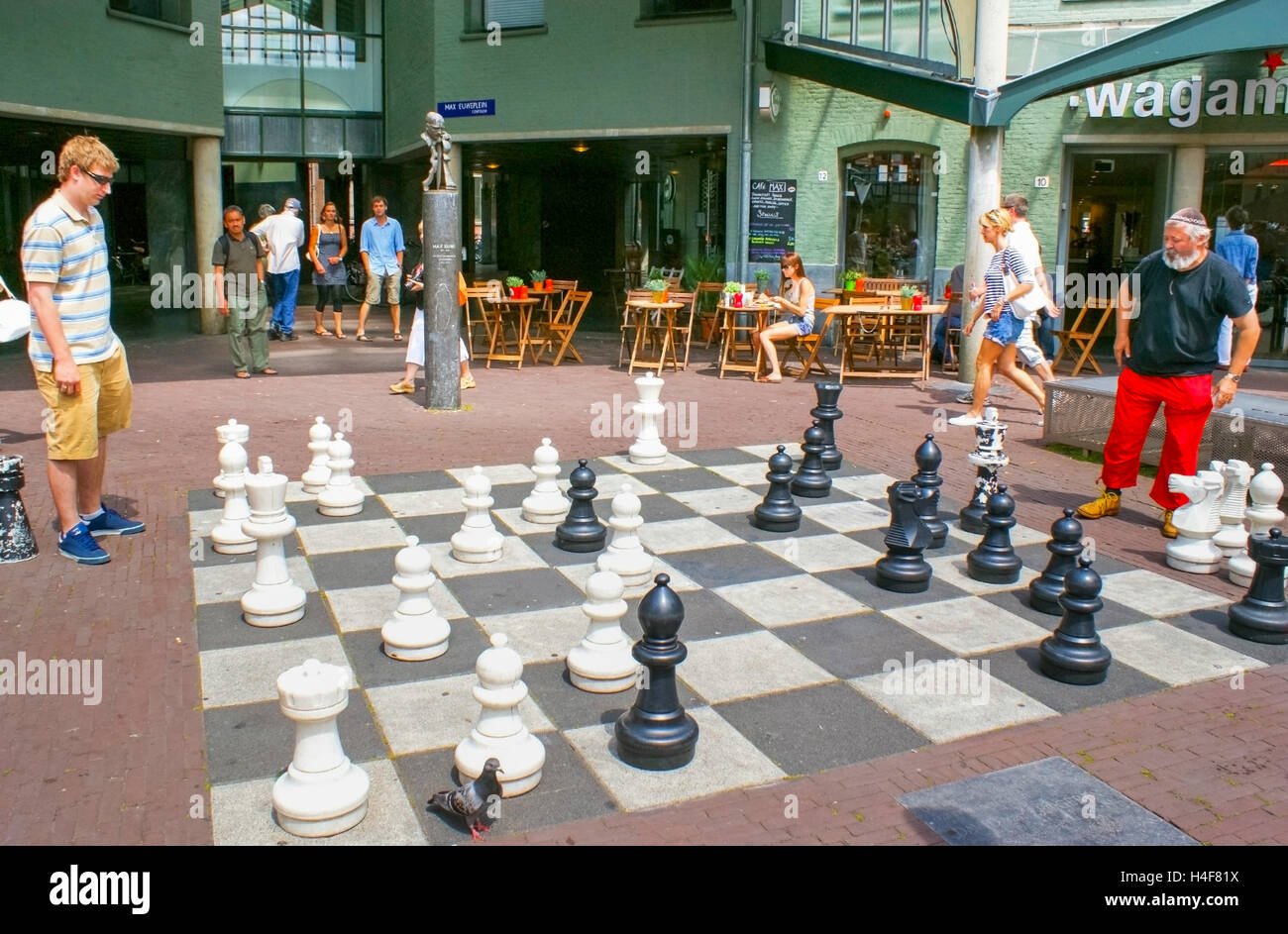 People playing chess on big chess board in the backyard of Max Euwe ...