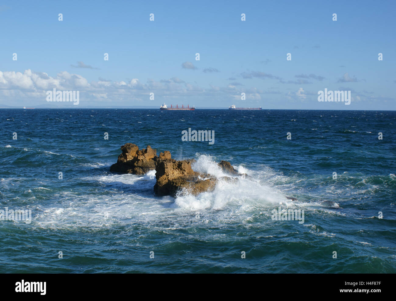 the view with the rocks in atlantic ocean and two barges on the ...