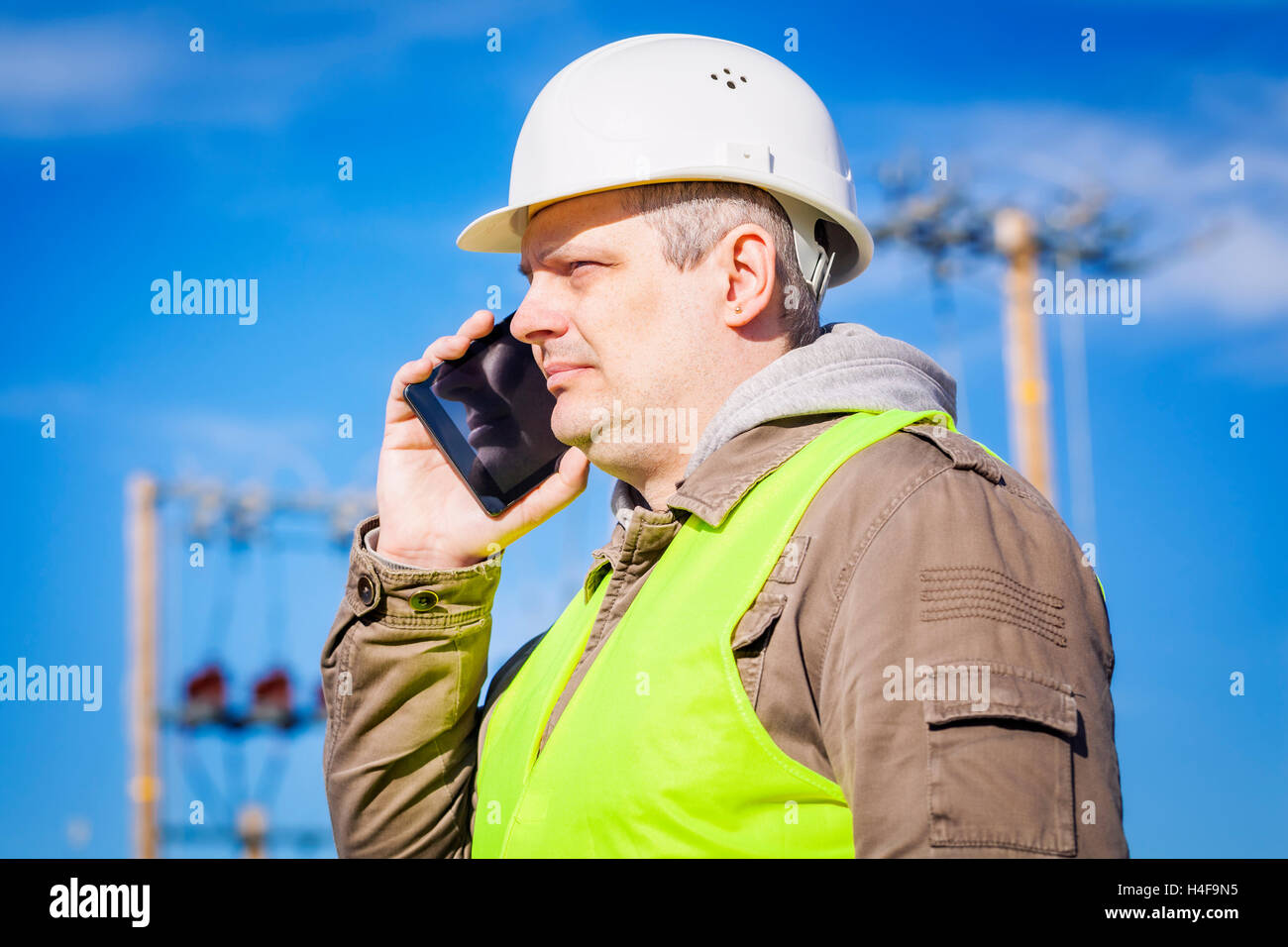 Electrical engineer talking on cell phone at outdoors Stock Photo - Alamy