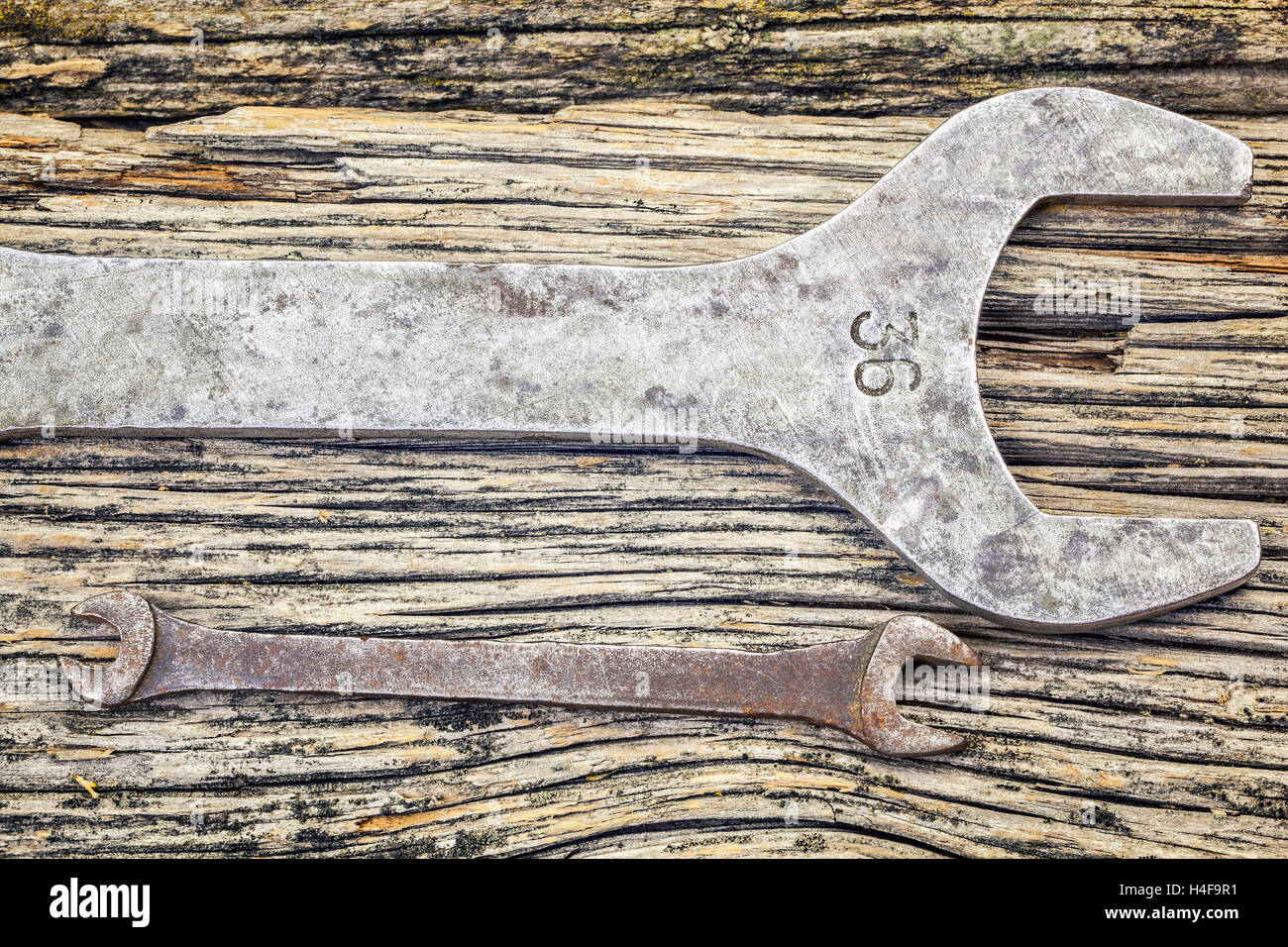 Two vintage metallic spanners on old wooden table Stock Photo - Alamy