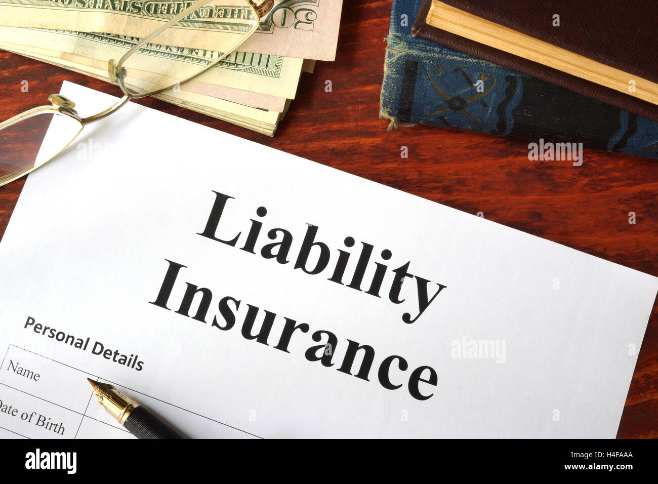 Liability insurance on a wooden table with glasses Stock Photo - Alamy