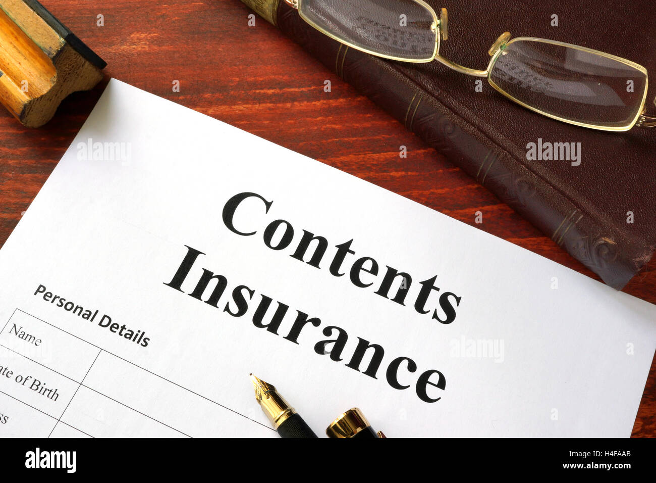 Contents insurance policy on a wooden surface with glasses Stock Photo ...