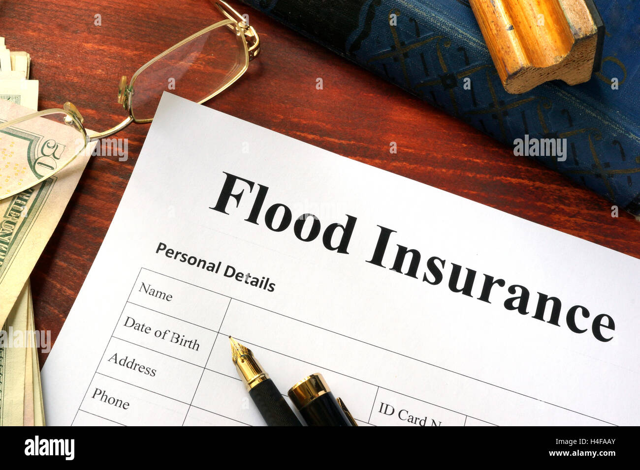 Flood insurance form on a table with a book Stock Photo - Alamy