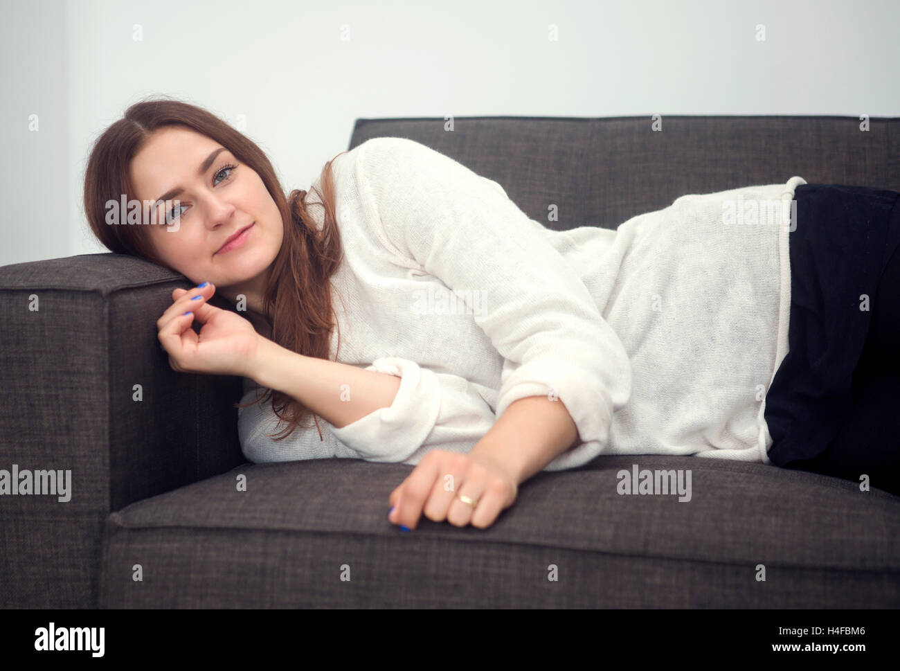 Brunette woman lying on couch hi-res stock photography and images - Alamy