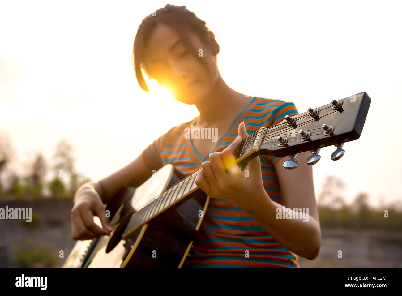Young women playing guitar at natural outdoor Stock Photo - Alamy