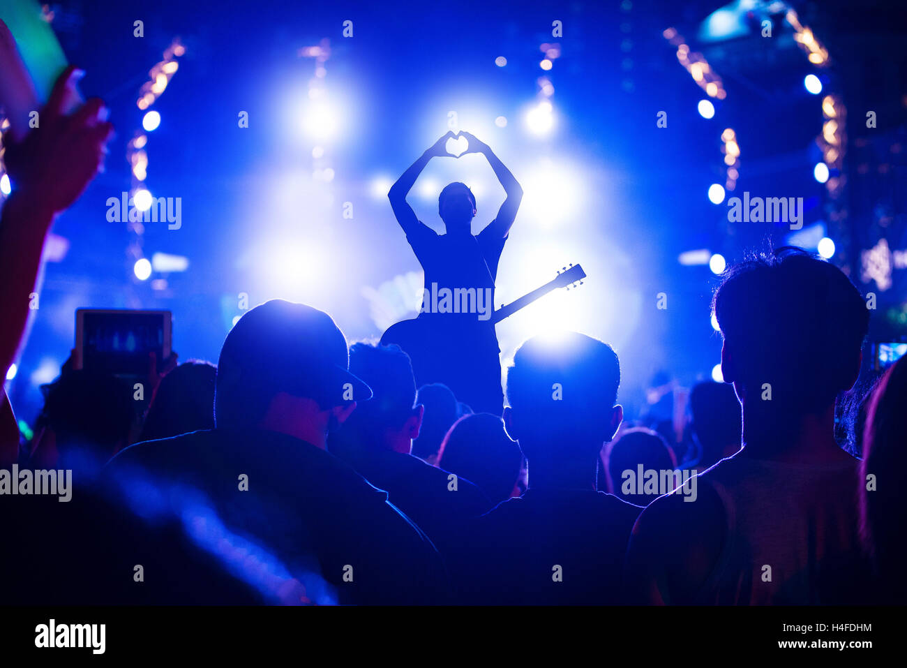 Singer singing on concert stage with ray of illuminated, Singer and ...
