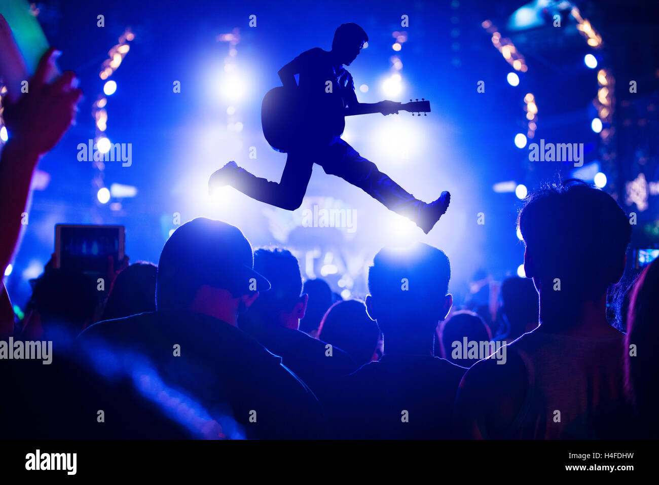 Singer singing on concert stage with ray of illuminated, Singer and ...