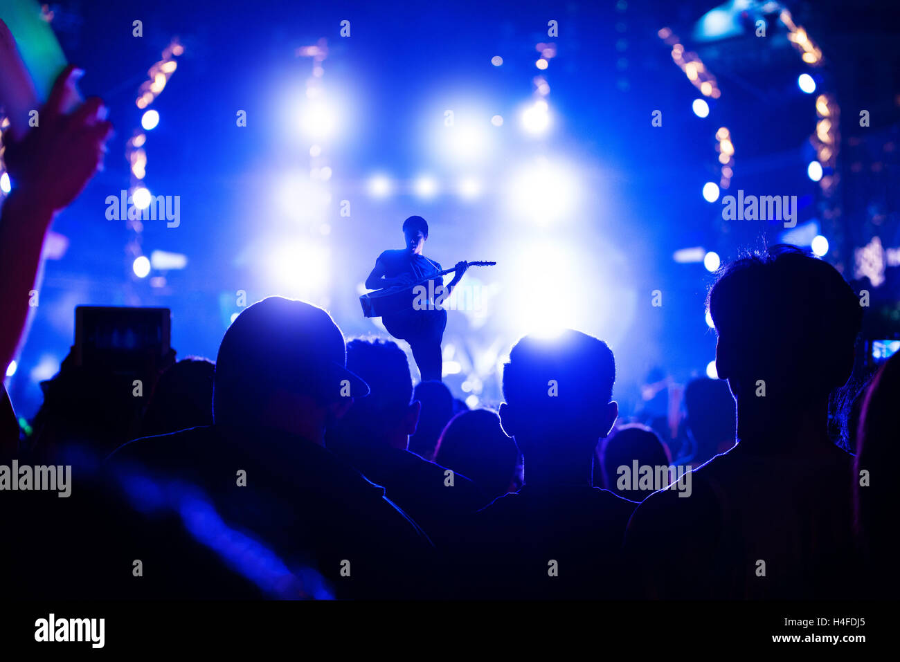 Singer singing on concert stage with ray of illuminated, Singer and ...