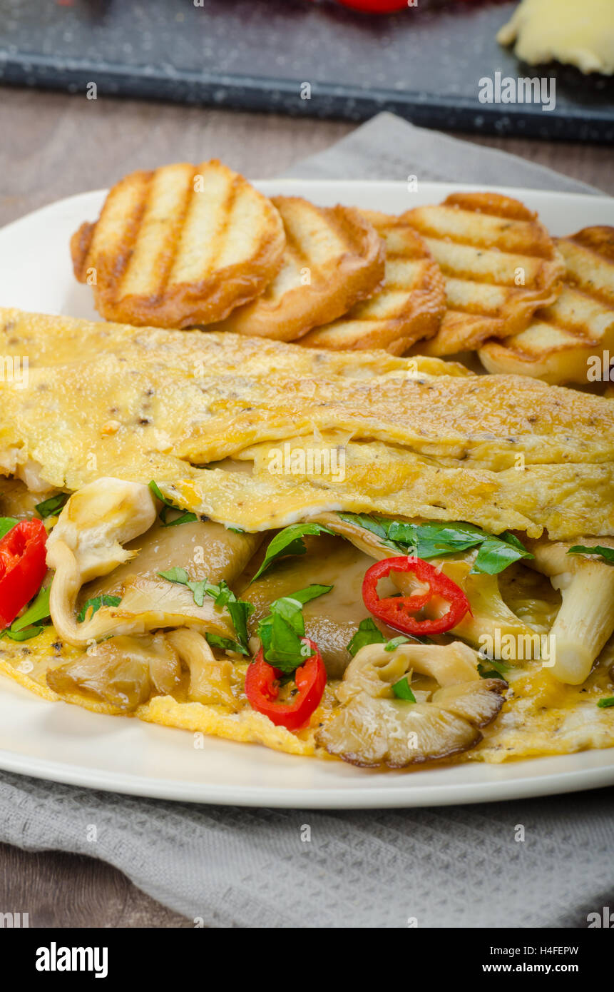 Rustic vegetarian omelette with chili peppers and mushrooms Stock Photo ...
