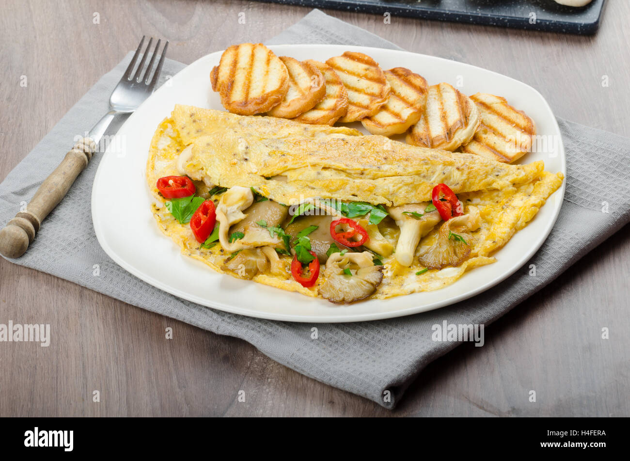 Rustic vegetarian omelette with chili peppers and mushrooms Stock Photo ...
