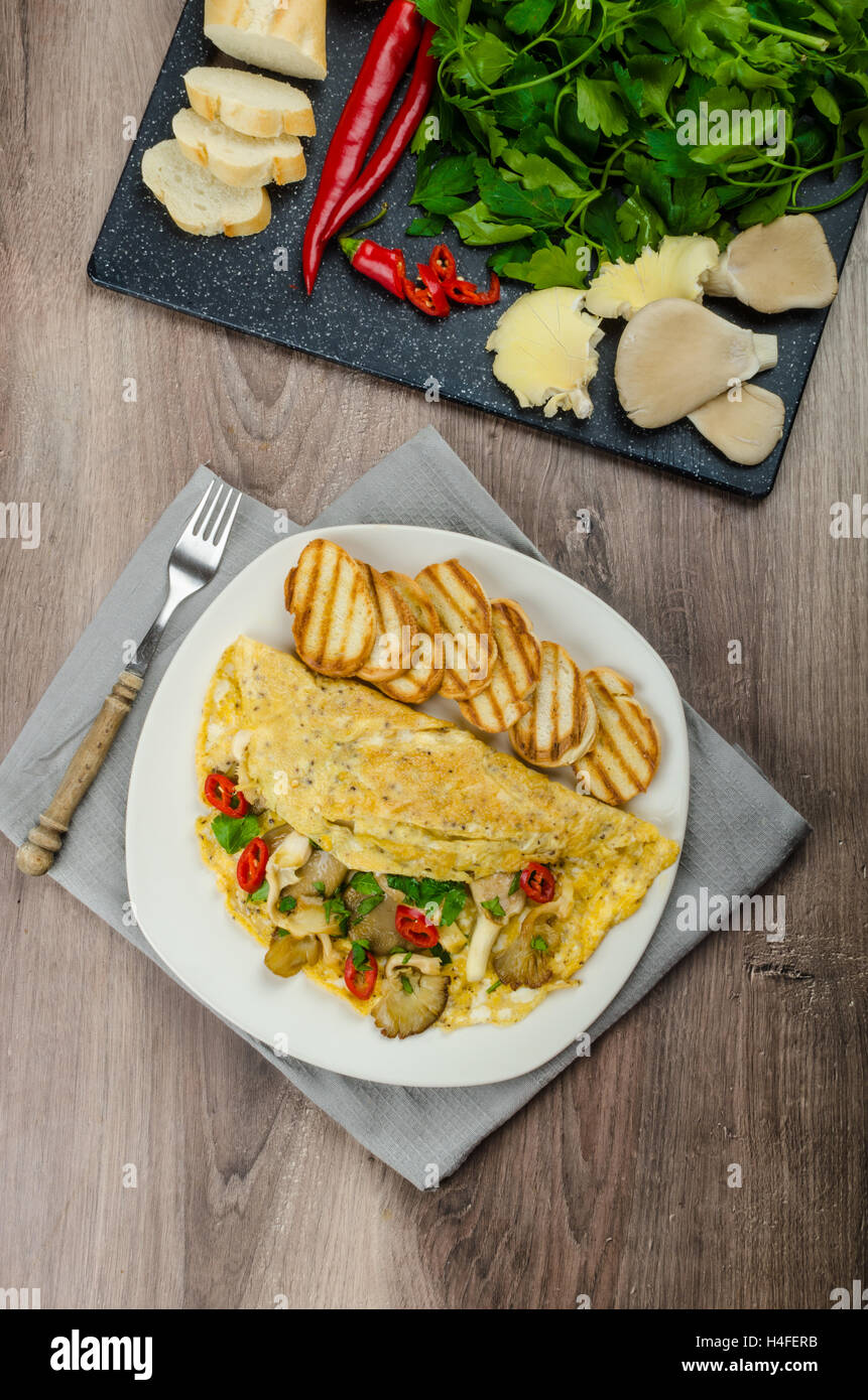 Rustic vegetarian omelette with chili peppers and mushrooms Stock Photo ...