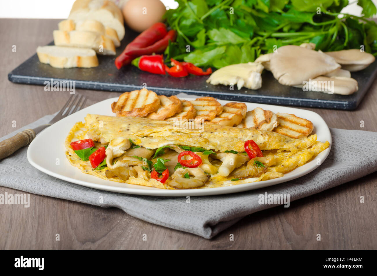 Rustic vegetarian omelette with chili peppers and mushrooms Stock Photo ...