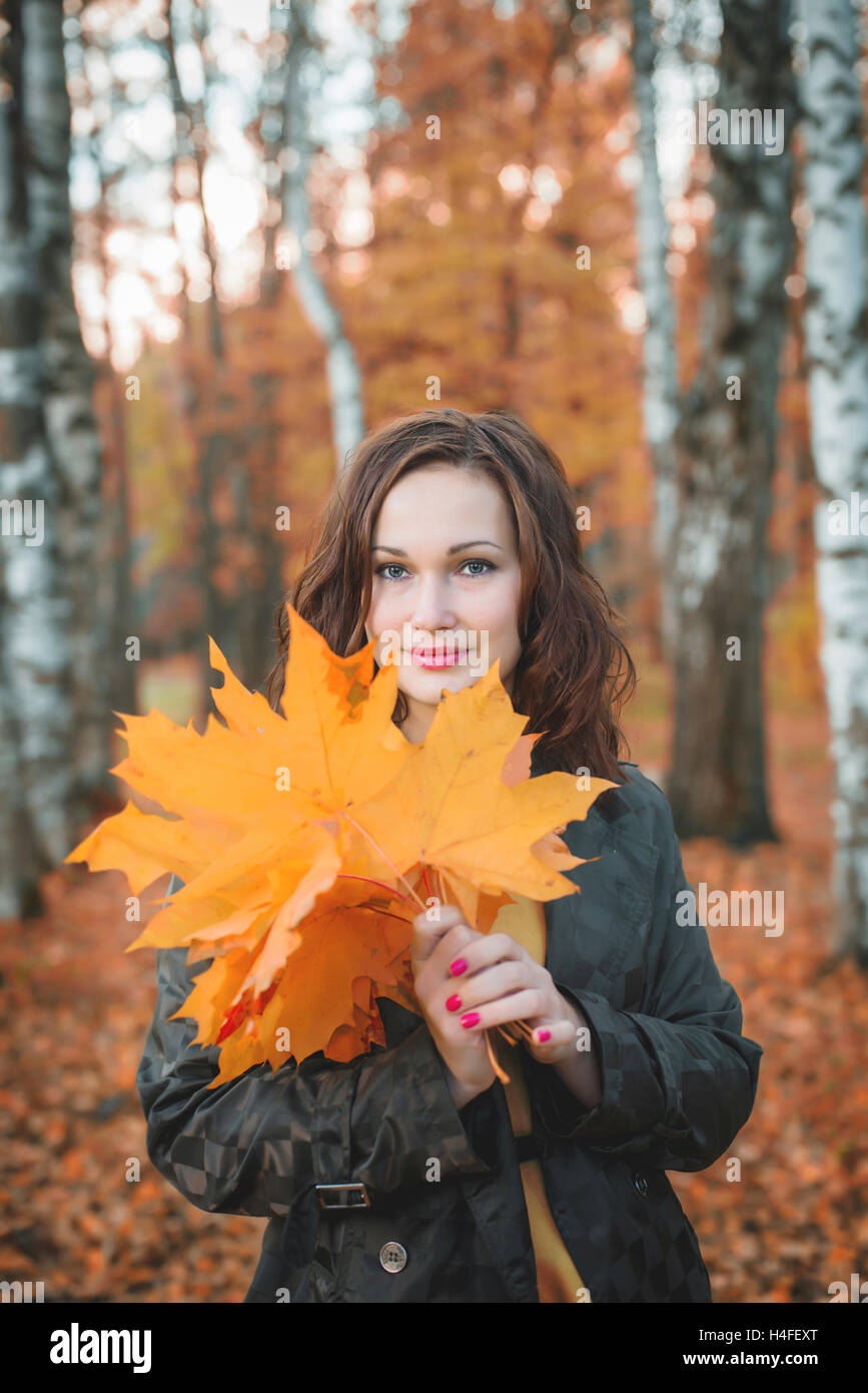 Young woman holding tree leaves Stock Photo - Alamy