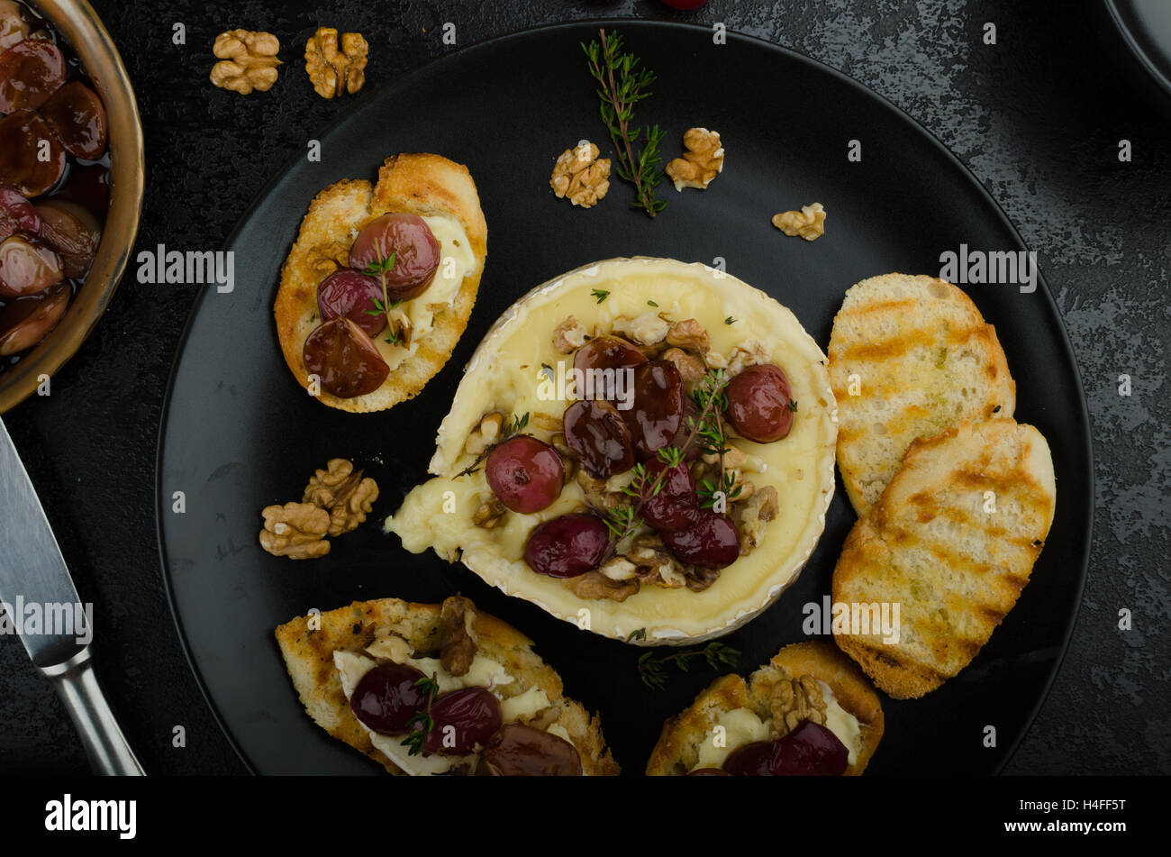 Brie cheese baked with nuts and grapes, tasty and crispy baguette and ...