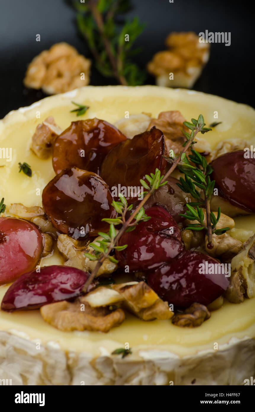 Brie cheese baked with nuts and grapes, tasty and crispy baguette and ...