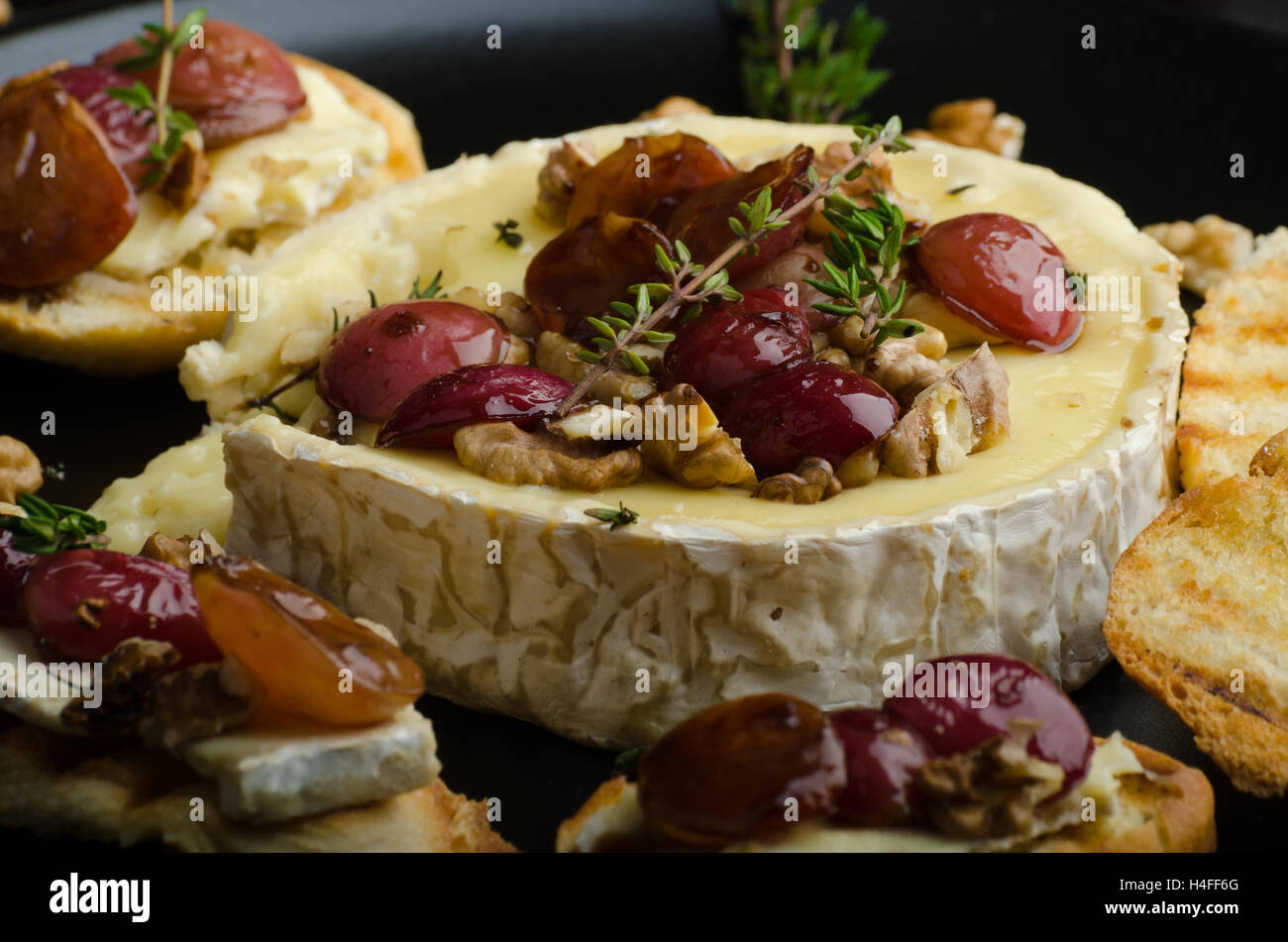 Brie cheese baked with nuts and grapes, tasty and crispy baguette and ...