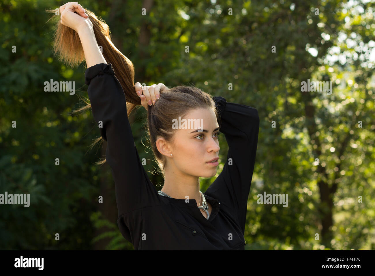 Young woman fixing her hair Stock Photo - Alamy