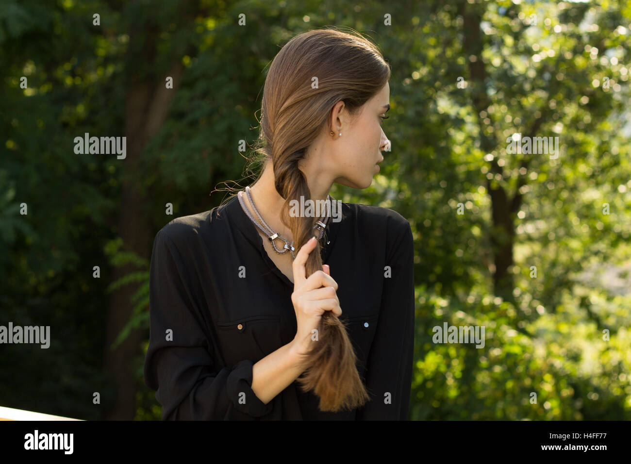 Young woman fixing her hair Stock Photo - Alamy