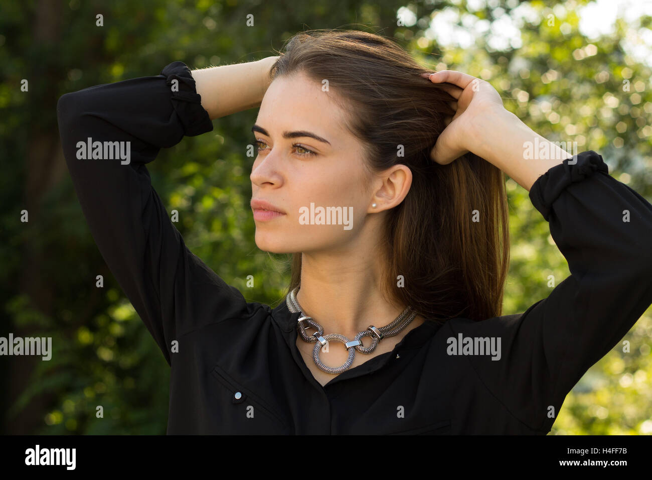 Young woman fixing her hair Stock Photo - Alamy