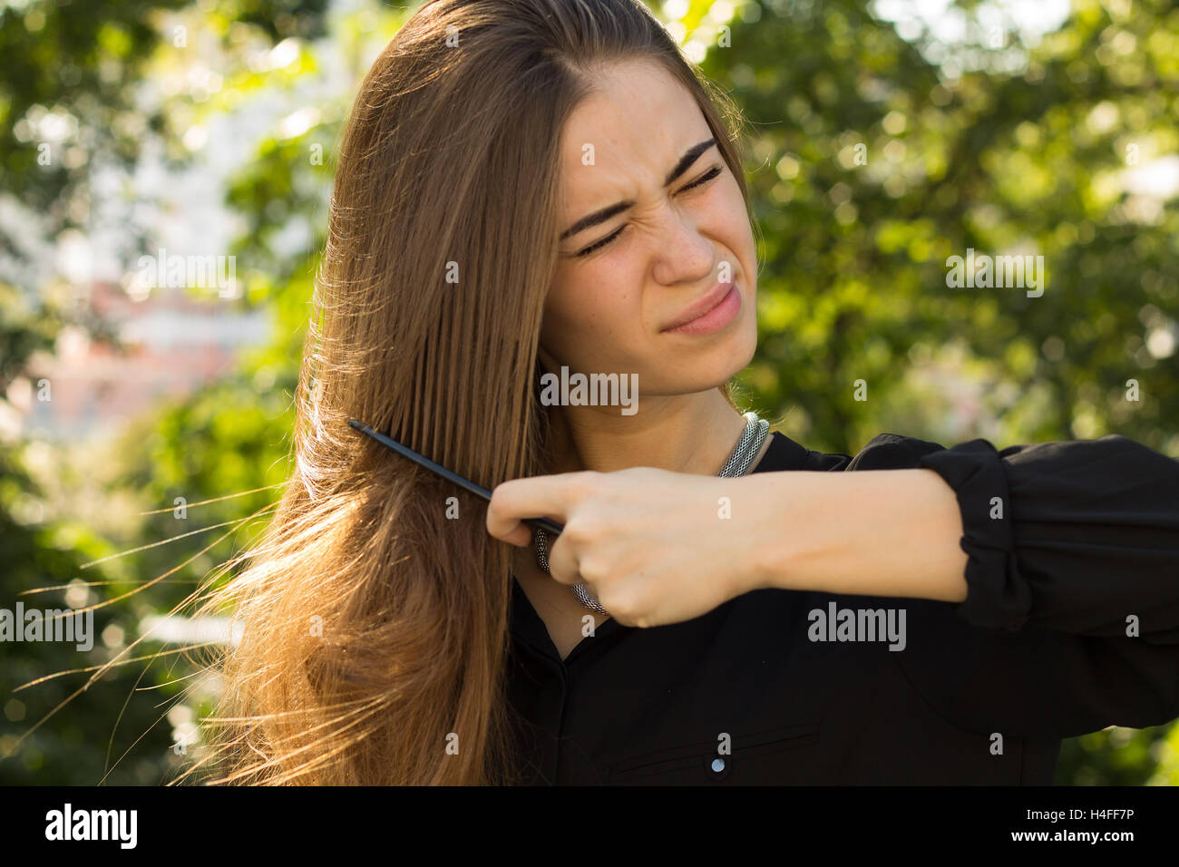 Woman combing her hair in the park Stock Photo - Alamy