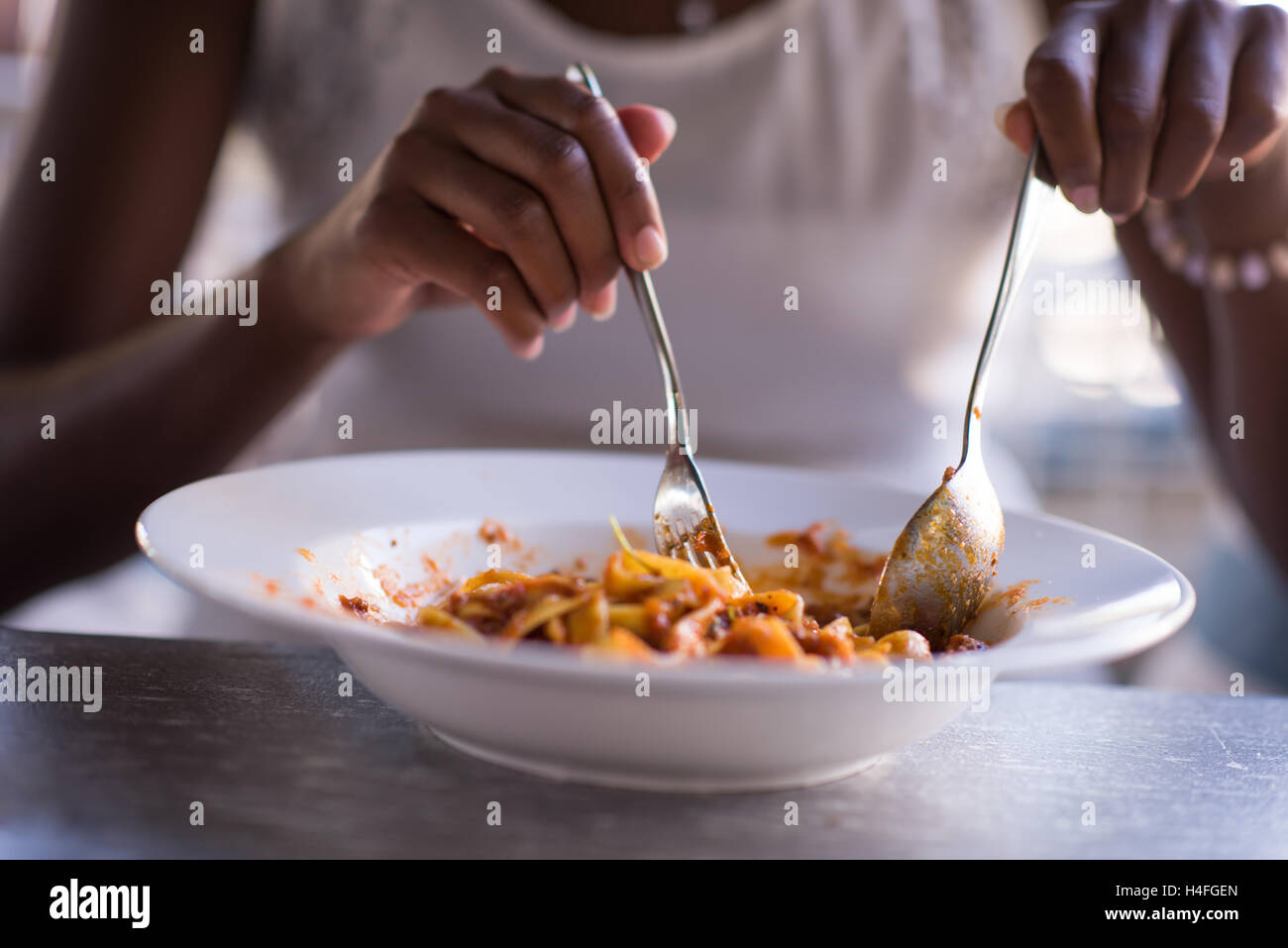 young beautiful African American woman enjoys while eating delicious ...