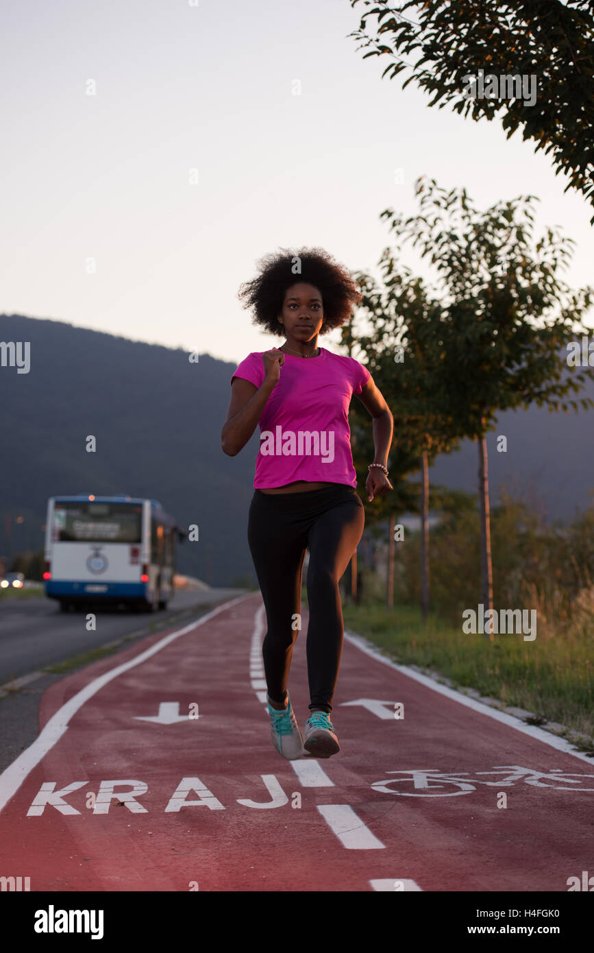 young beautiful African American woman enjoys running outside beautiful ...